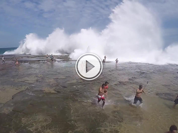 Freakishly large wave wipes out beachgoers (Video)