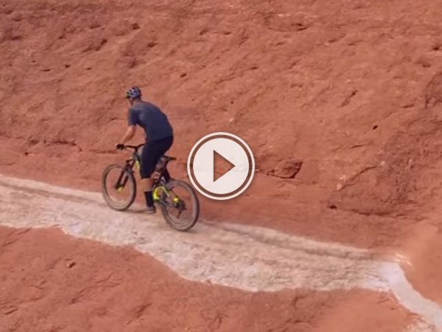 Cycling Along White Line Trail On Edge Of Cliff (Video)